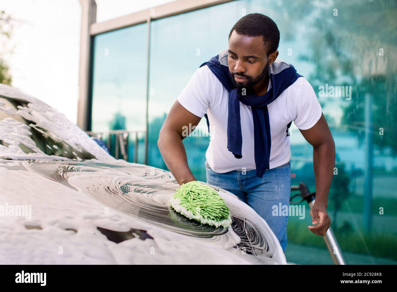 Young attractive African American man washing his modern electric ...