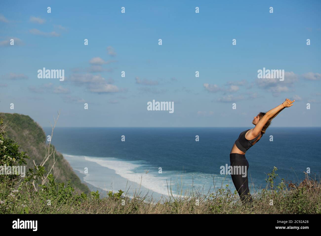 Young woman doing yoga outdoors with amazing back view. Bali. Indonesia ...