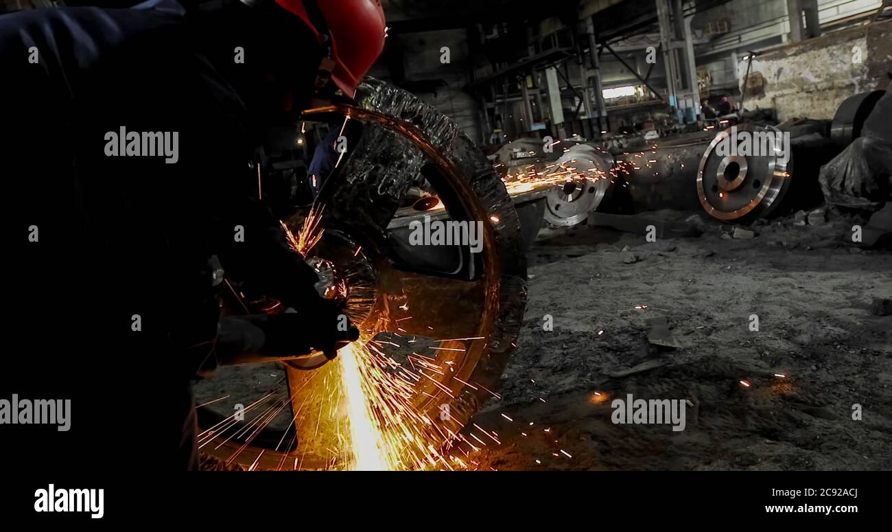 Working in a mask and headphones cleans joints angle grinder on metal ...