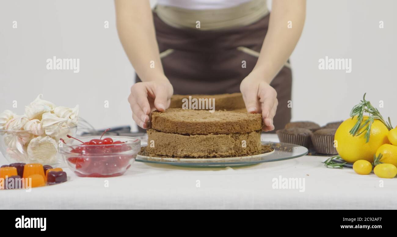 Step by step. Girl assembling a chocolate cake with bright colorful ...