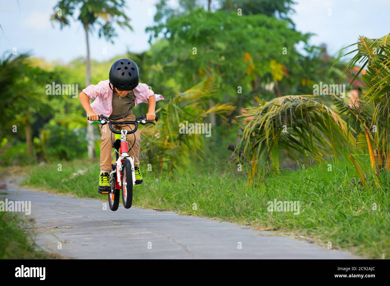 Country cycling walk. Young rider kid in helmet and sunglasses riding ...