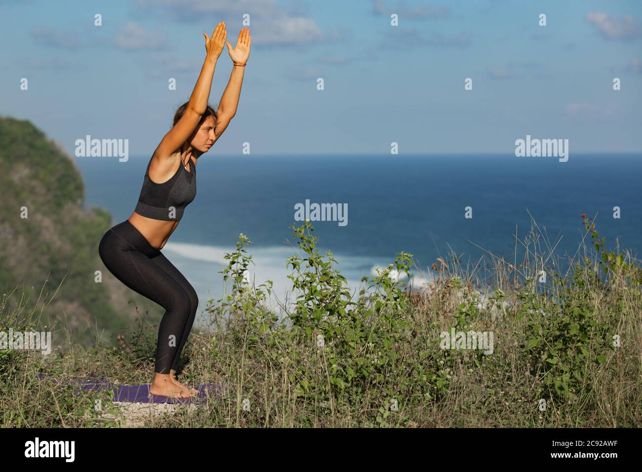 Young woman doing yoga outdoors with amazing back view. Bali. Indonesia ...