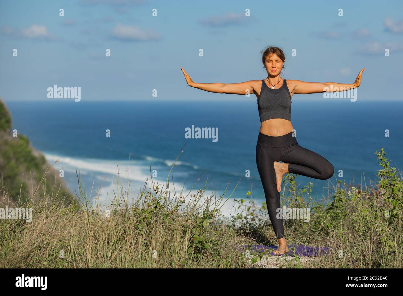 Young woman doing yoga outdoors with amazing back view. Bali. Indonesia ...