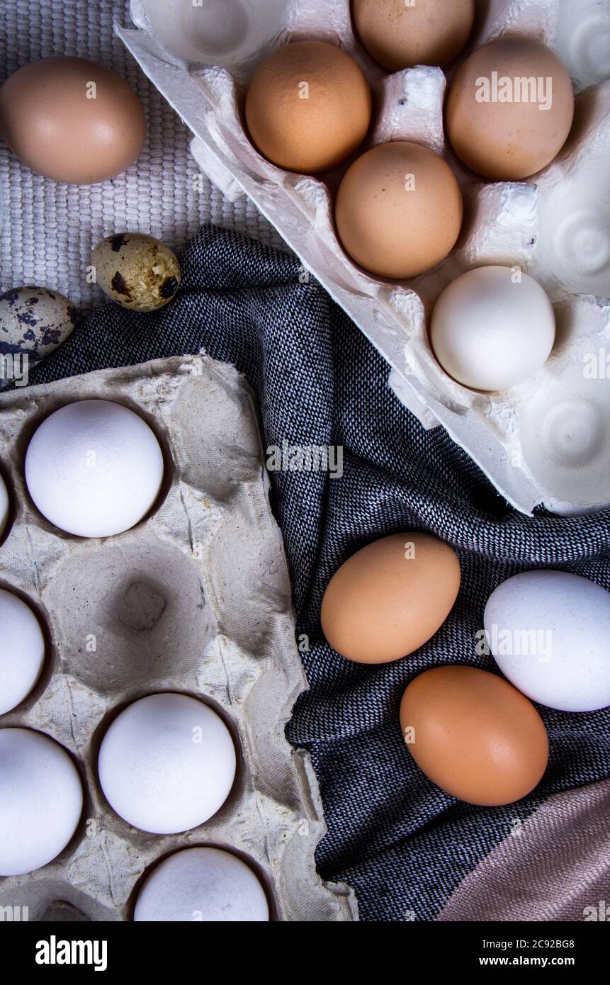 Some healthy native eggs and quail eggs are in a wooden basket next to ...