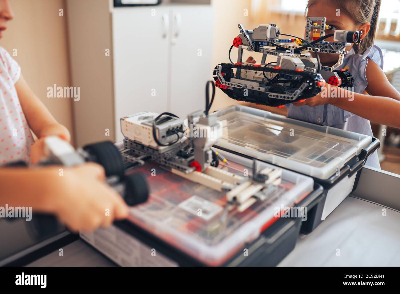 Two schoolgirls study in a robotics class, assemble a robot constructor ...