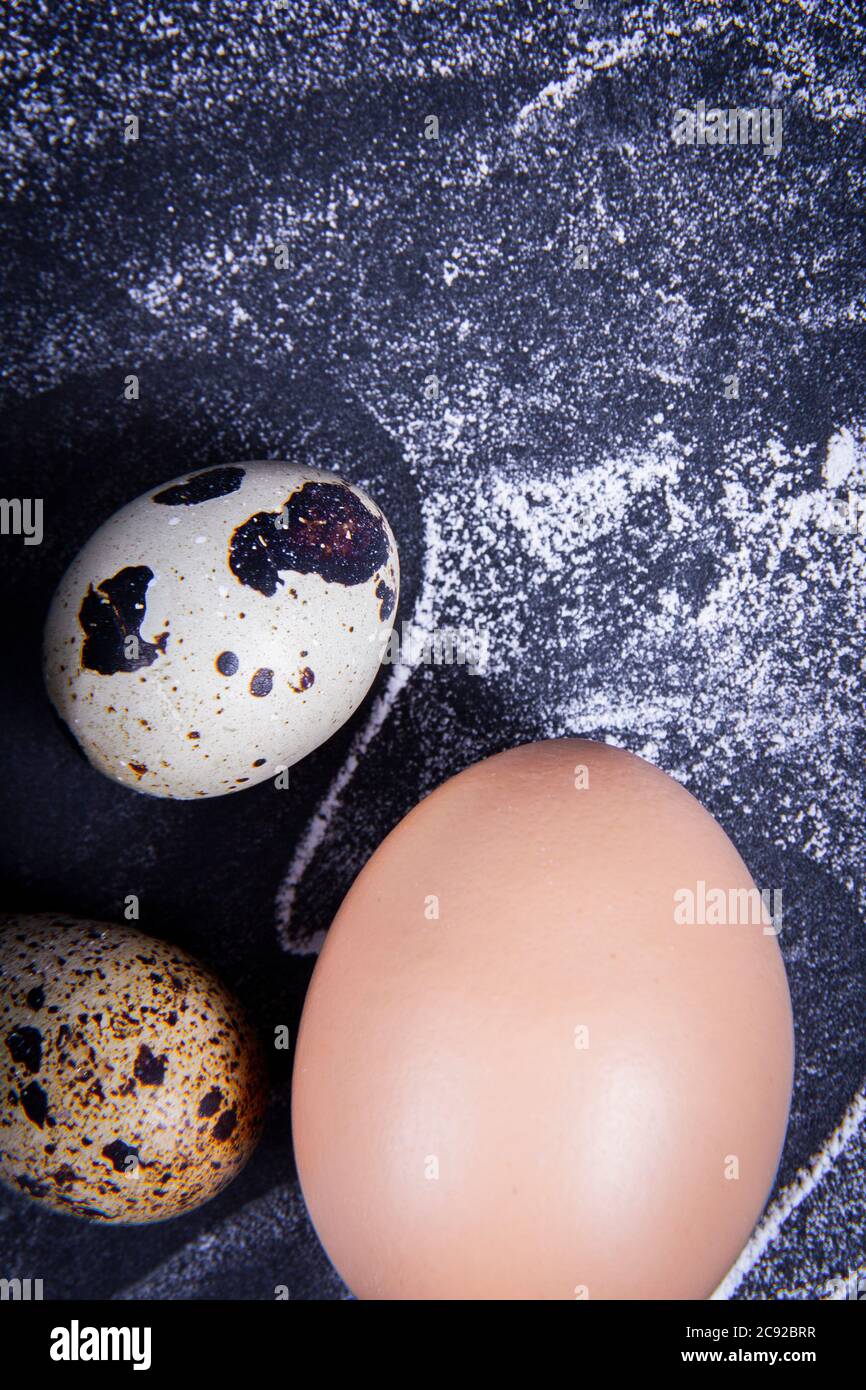 Some healthy native eggs and quail eggs are in a wooden basket next to ...