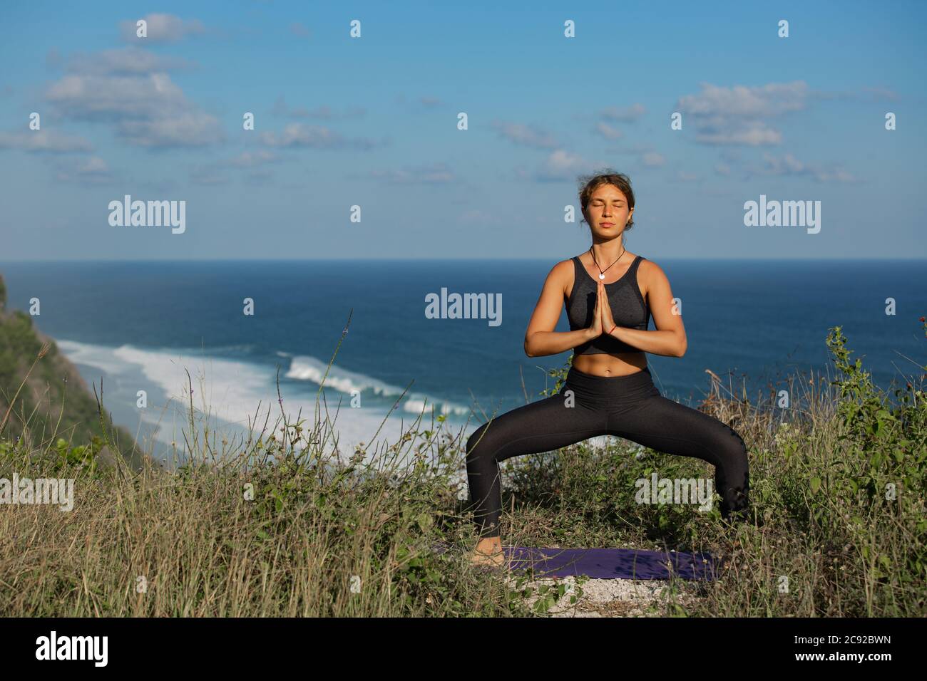 Young woman doing yoga outdoors with amazing back view. Bali. Indonesia ...