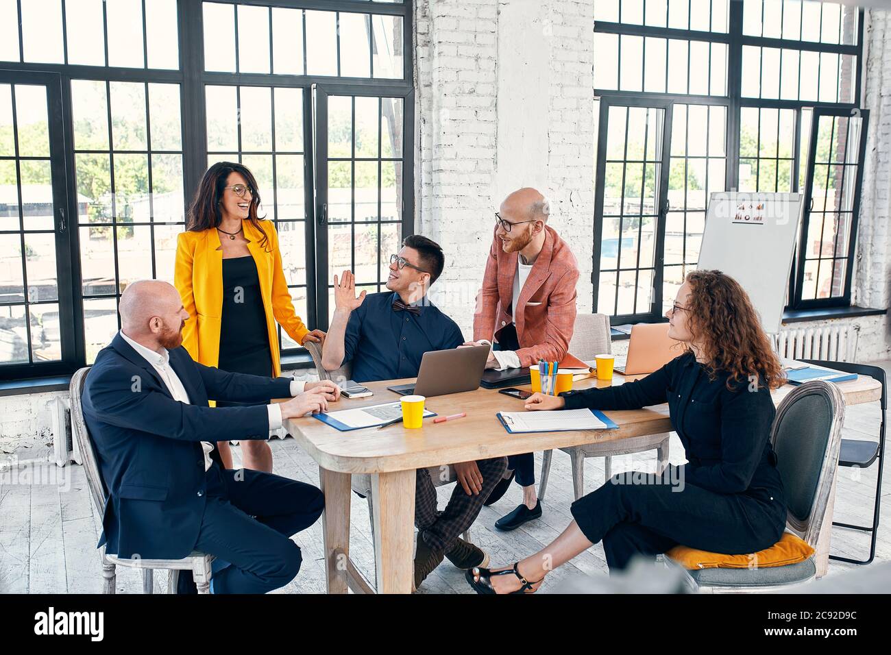 Beautiful business people are using gadgets, talking and smiling during ...