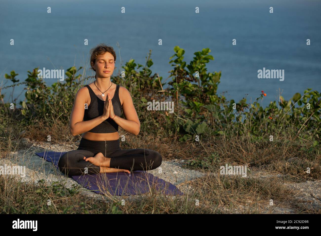 Young woman doing yoga outdoors with amazing back view. Bali. Indonesia ...