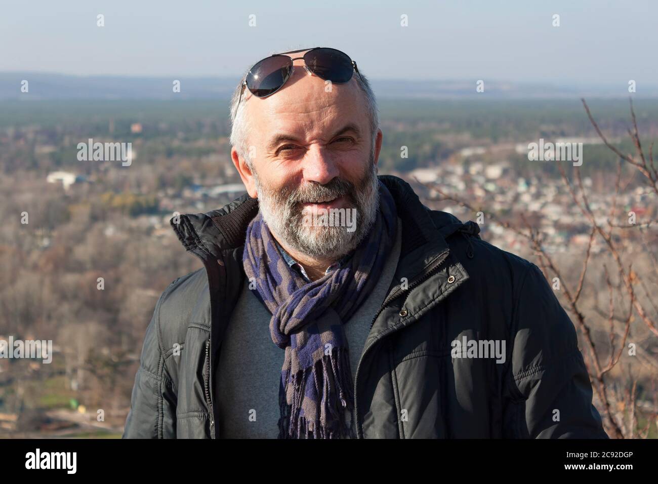 Portrait of a mature man in a jacket with a scarf tied around his neck ...
