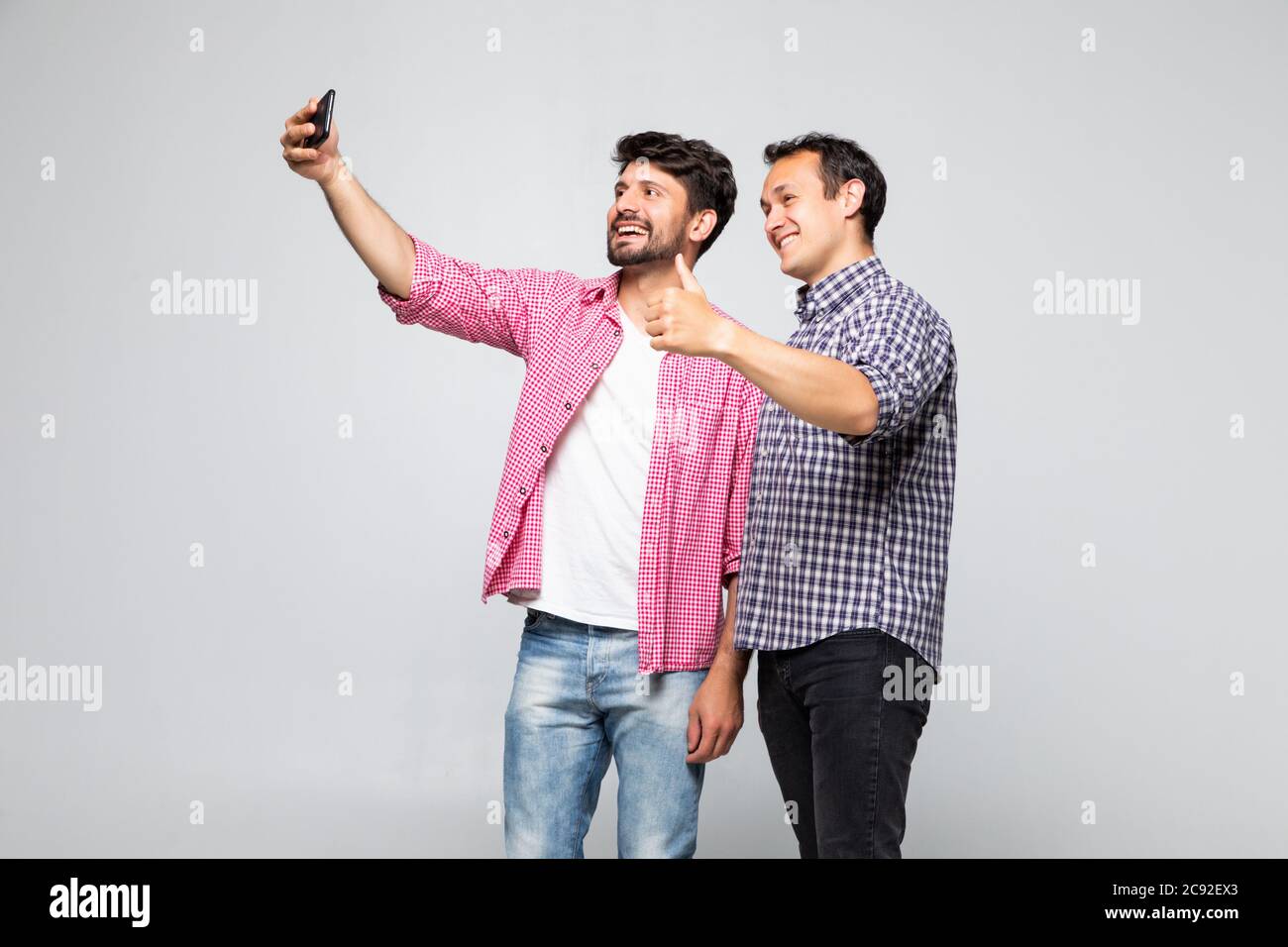 Portrait of a two excited young men taking a selfie while standing ...