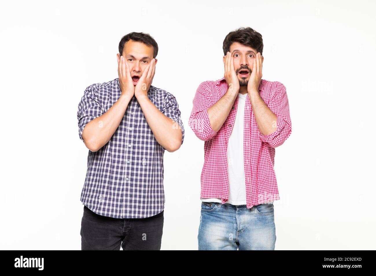 Two young men shocked expresion on white background Stock Photo - Alamy