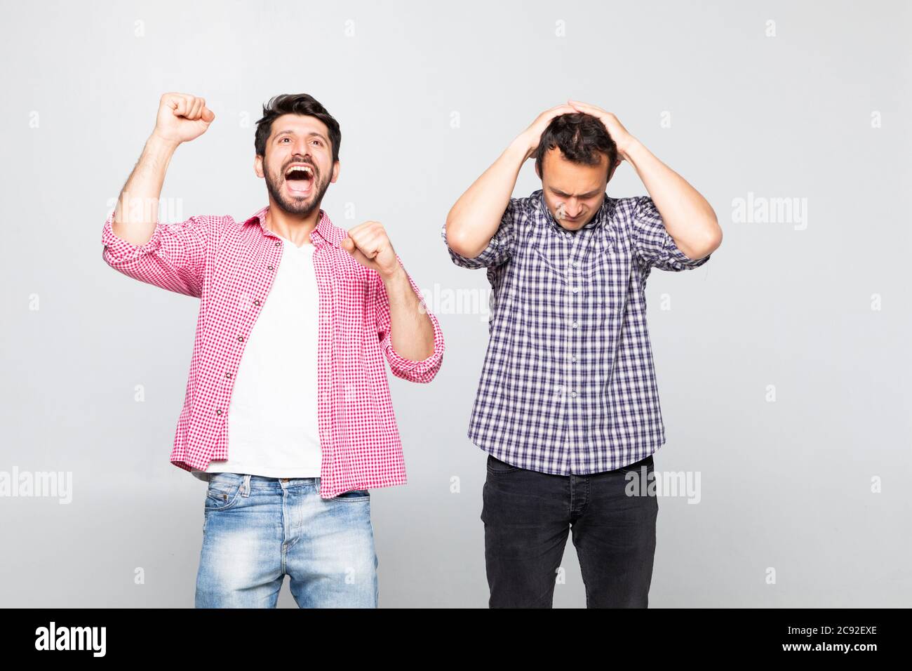 Portrait of a two men one win one sad of lose over white background ...