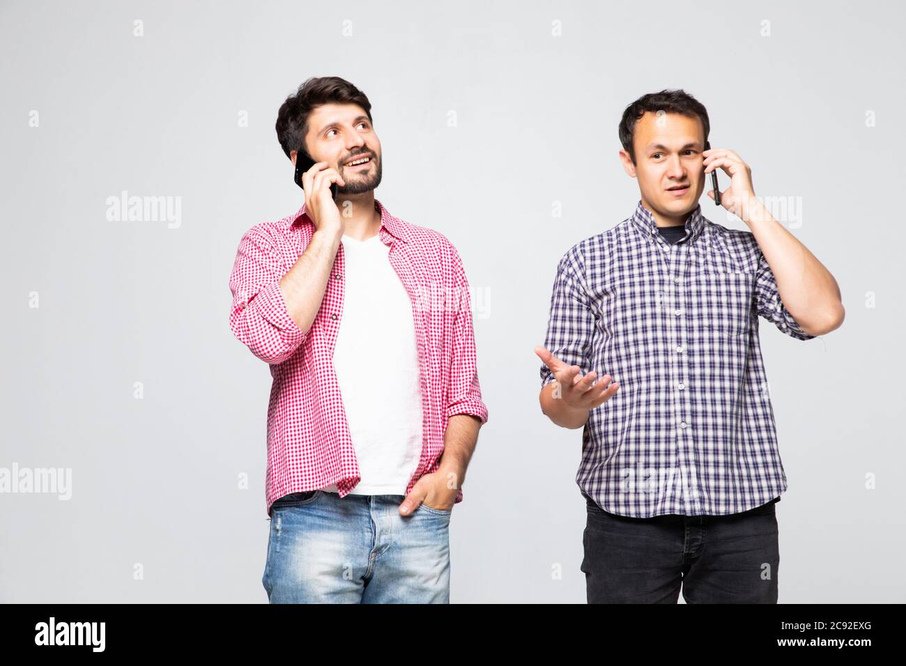 Two men having conversation by phones mobile isolated on white ...