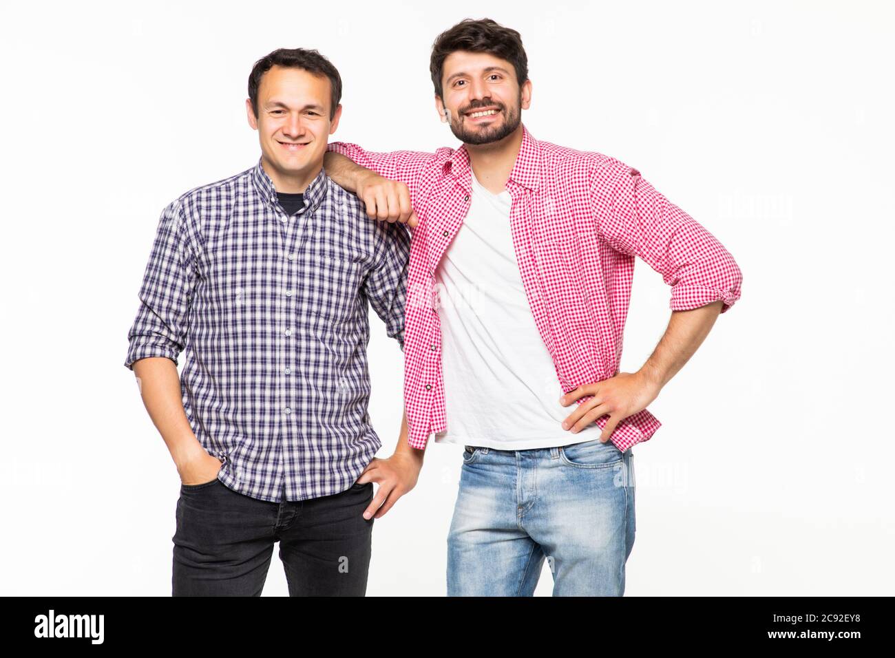 Two handsome men wearing casual t-shirt and jeans smiling and posing ...