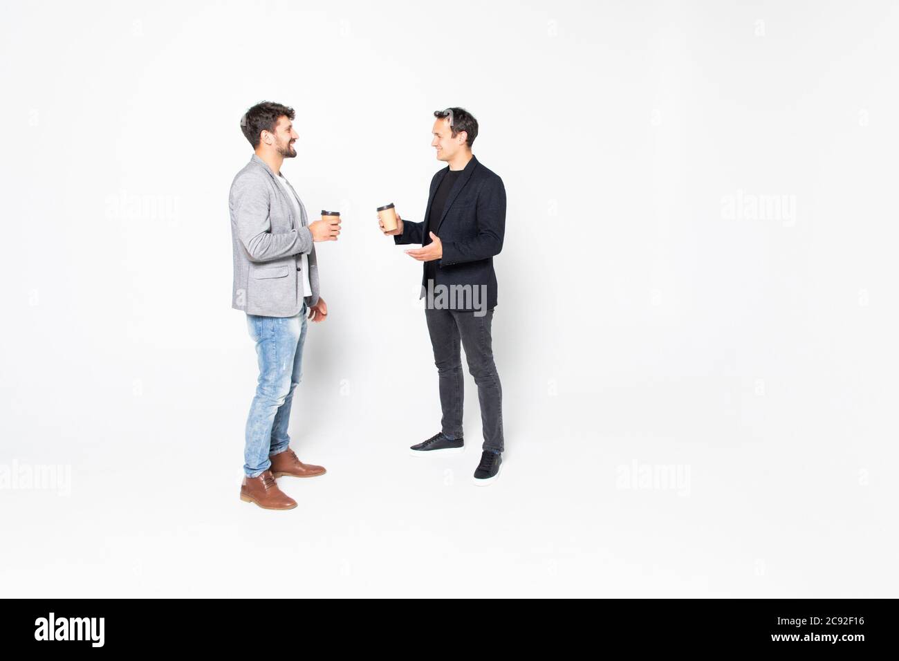 Young two men corporate executives standing and talking with coffee on ...