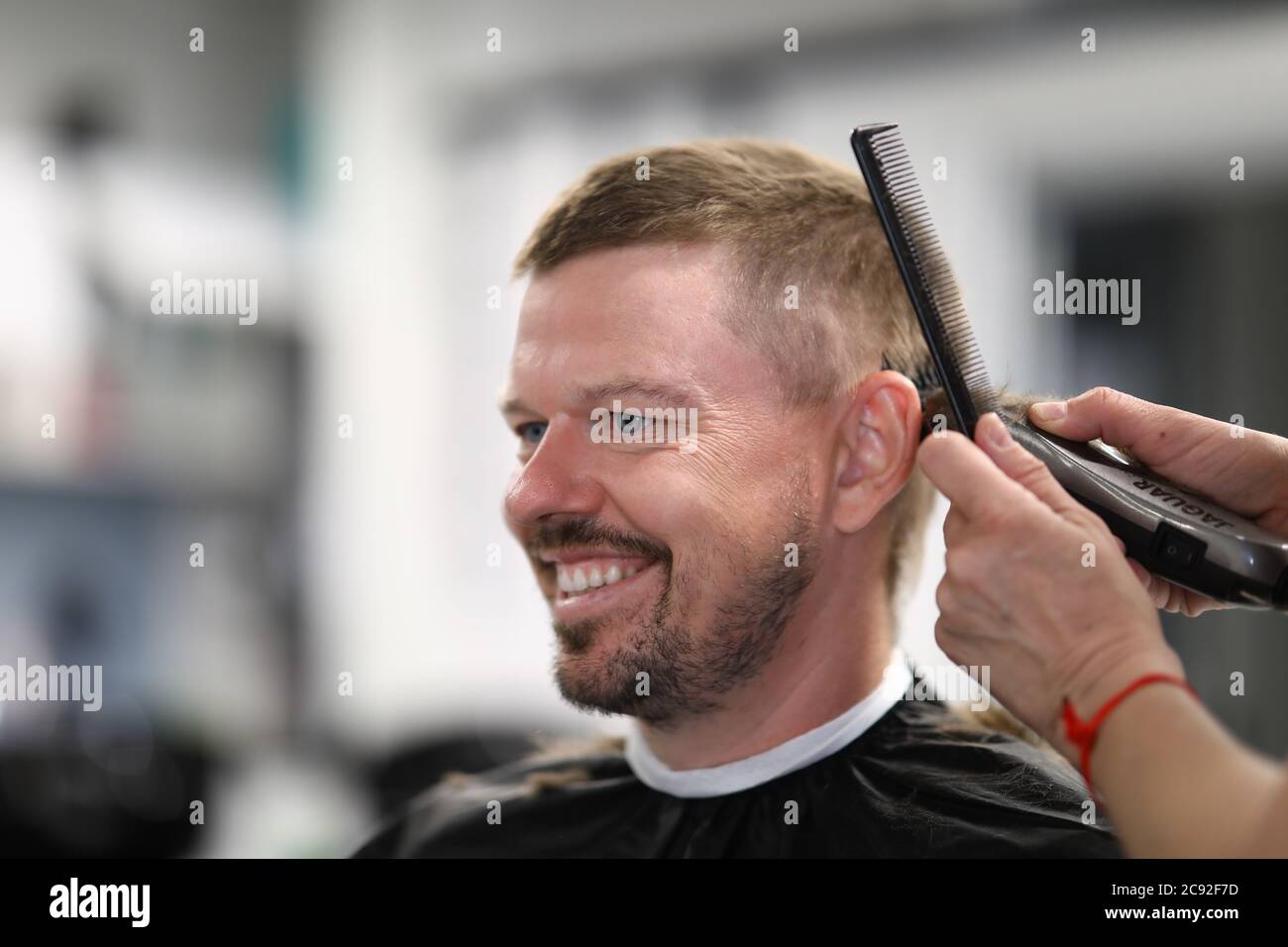 Barber cuts man in beauty hi-res stock photography and images - Alamy