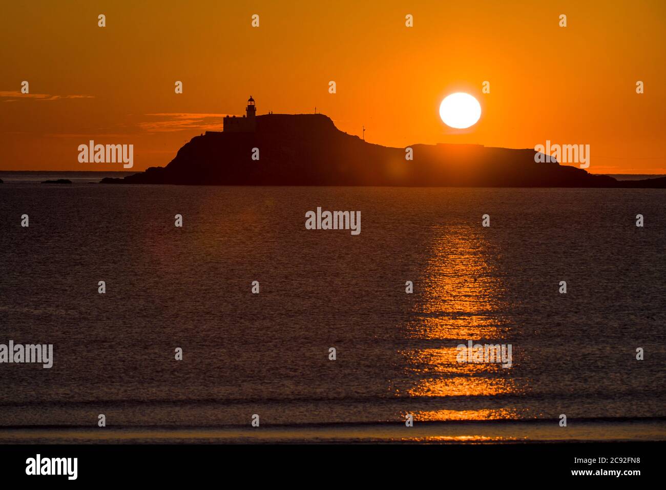 An early morning sunrise is seen over the fortress of solitude beach of ...