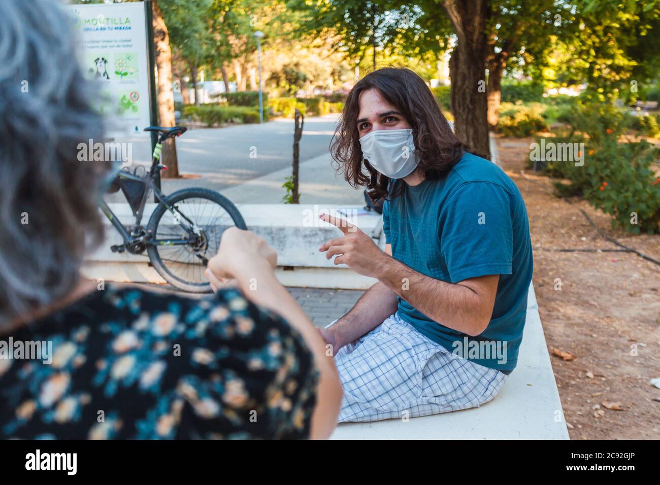 People talking wearing masks and keeping social distance Stock Photo ...
