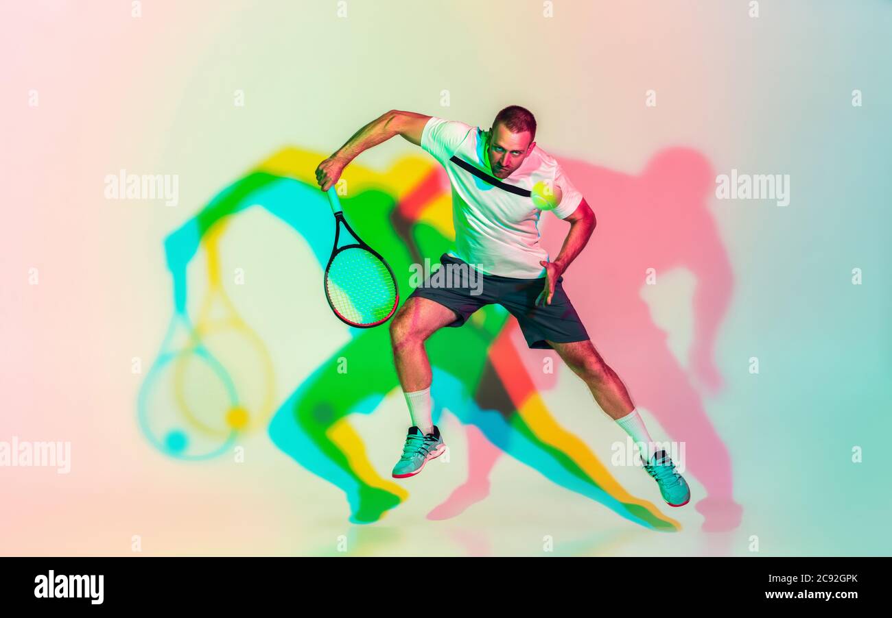 In jump. One caucasian man playing tennis on studio background in ...