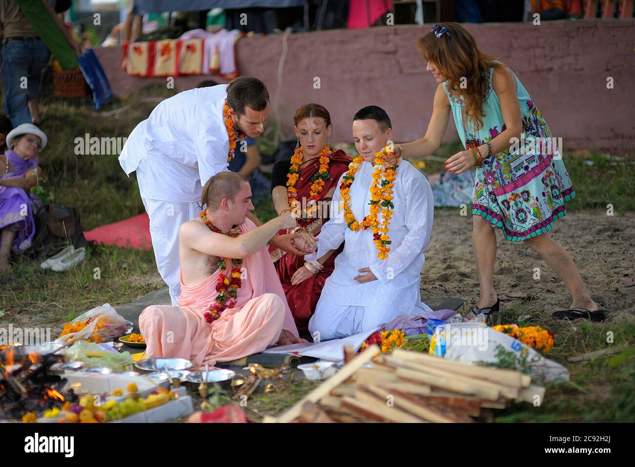 Vedic wedding. Bride and groom in wedding dresses sitting on the ground ...