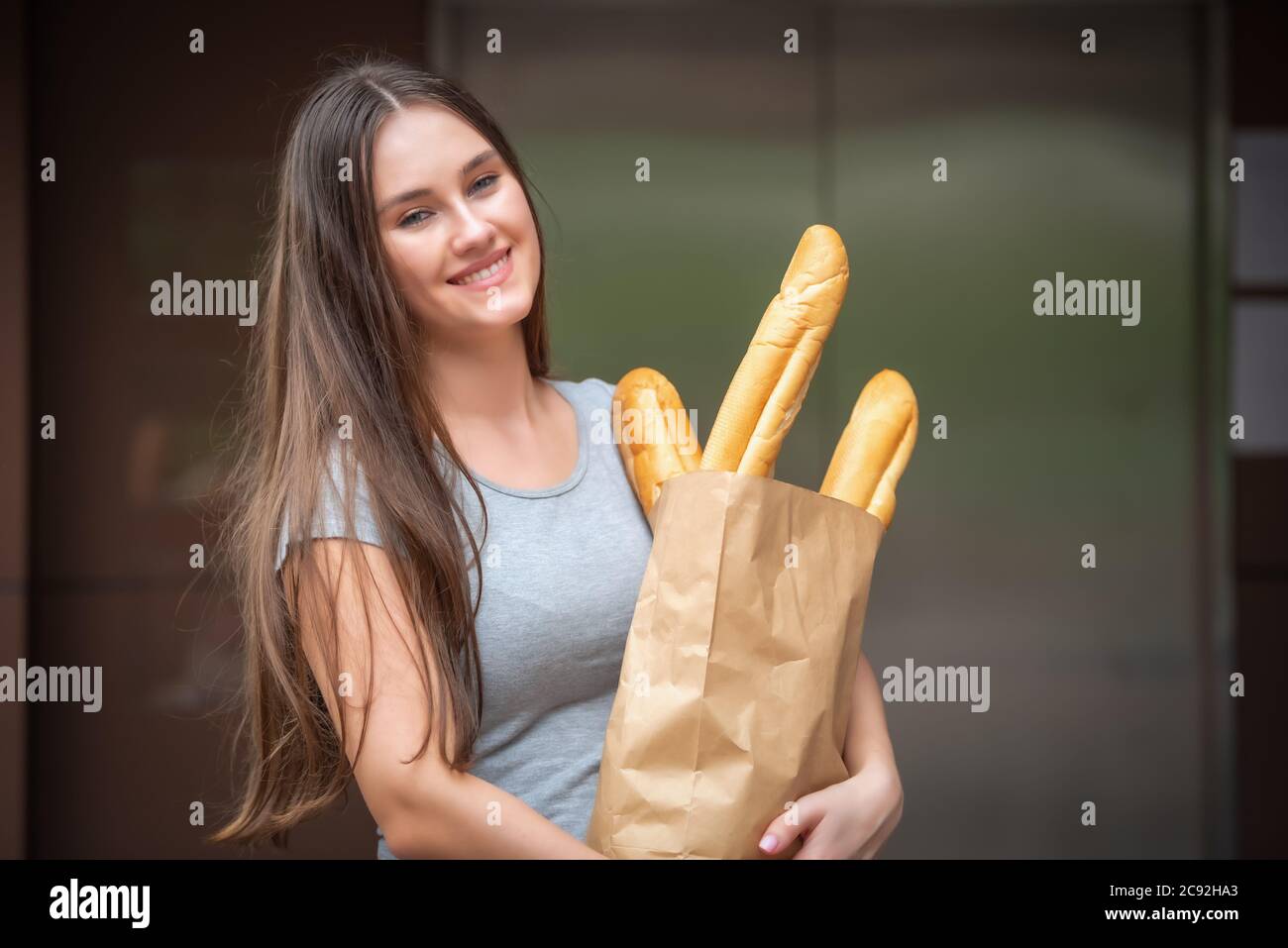 Woman receiving food package from delivery service company staff at ...