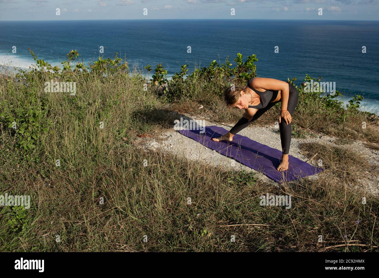 Young woman doing yoga outdoors with amazing back view. Bali. Indonesia ...