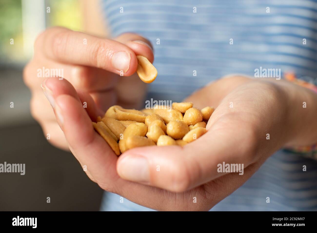 Close Up Of Teenage Girl Eating Handful Of Salted Peanuts Stock Photo ...