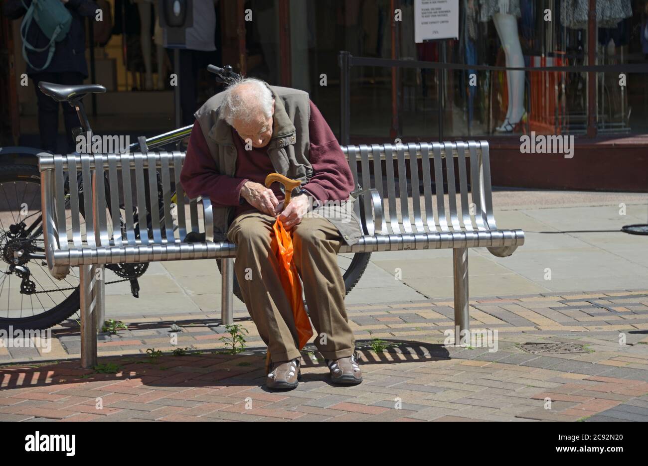 Old chap taking a nap on a bench, while out shopping Stock Photo - Alamy