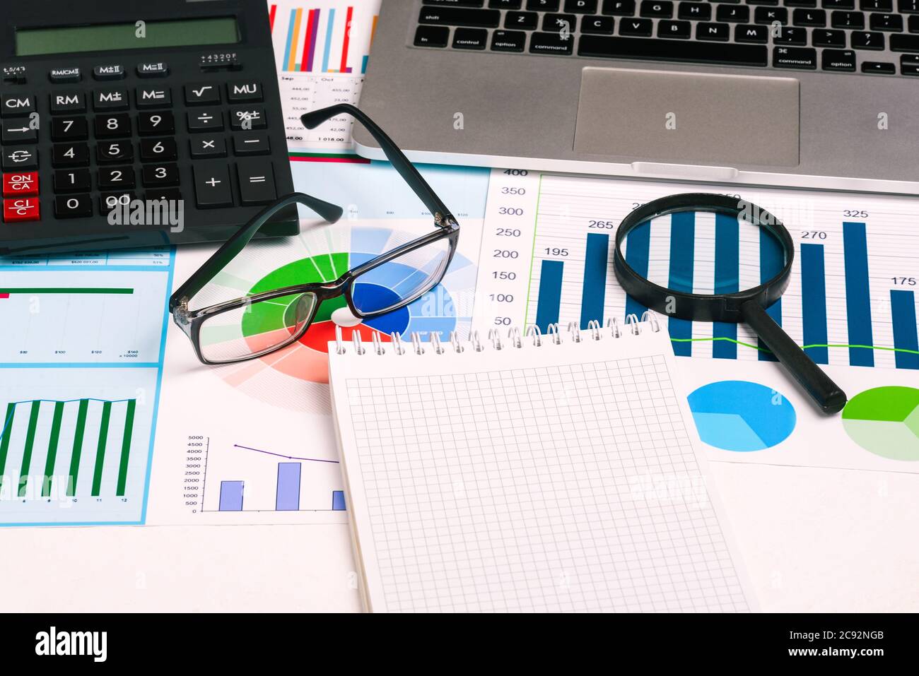 Office Desk with financial papers, charts, magnifying glass, calculator ...