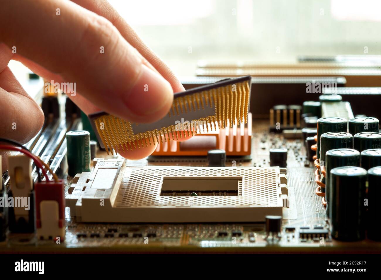 Technician plug in CPU microprocessor to motherboard socket, evident ...