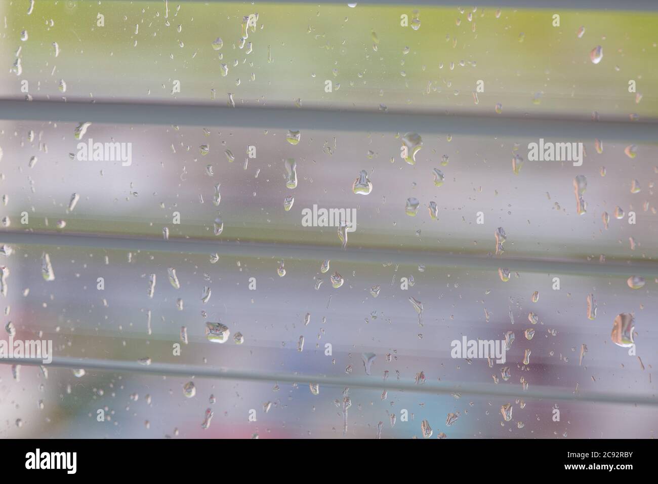 The rain behind a window drips on glass a look through the opening ...
