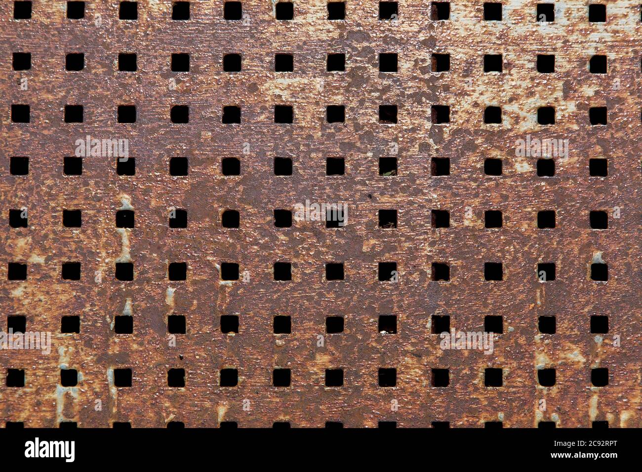 The texture of rusty metal with square holes, the cover of the old ...