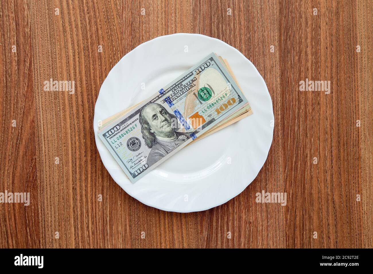 Wooden table on which there is a plate in which the denomination ...