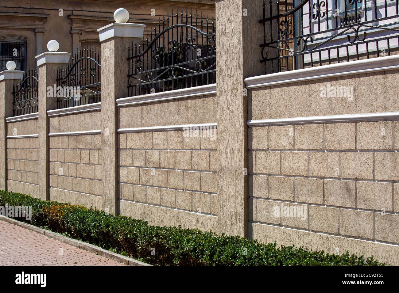 High stone fence with the bushes growing before a wall Stock Photo - Alamy