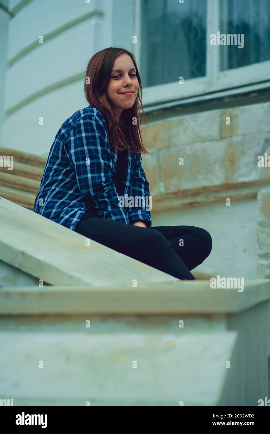 Young pretty woman poses on stairs of manor. Adult smiley female ...