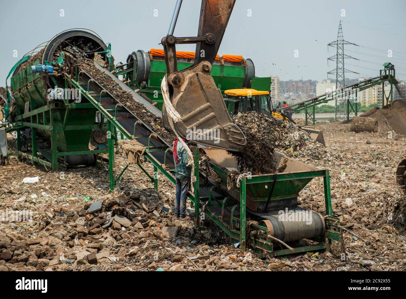 A JCB machine feeding waste in the plant for the segregation process ...