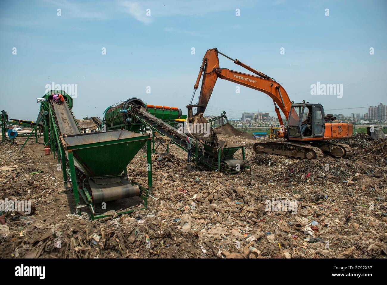 A JCB machine feeding waste in the plant for the segregation process ...