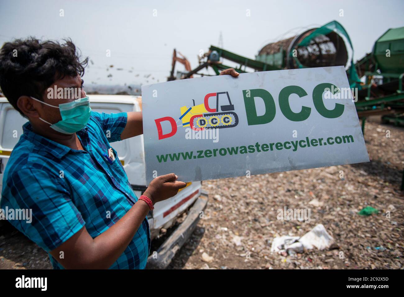 A man showing a company's logo (DCC) of the project under which ...