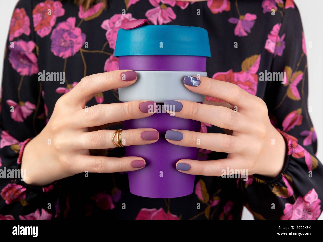 Woman in floral pattern dress holds a reusable cup Stock Photo - Alamy