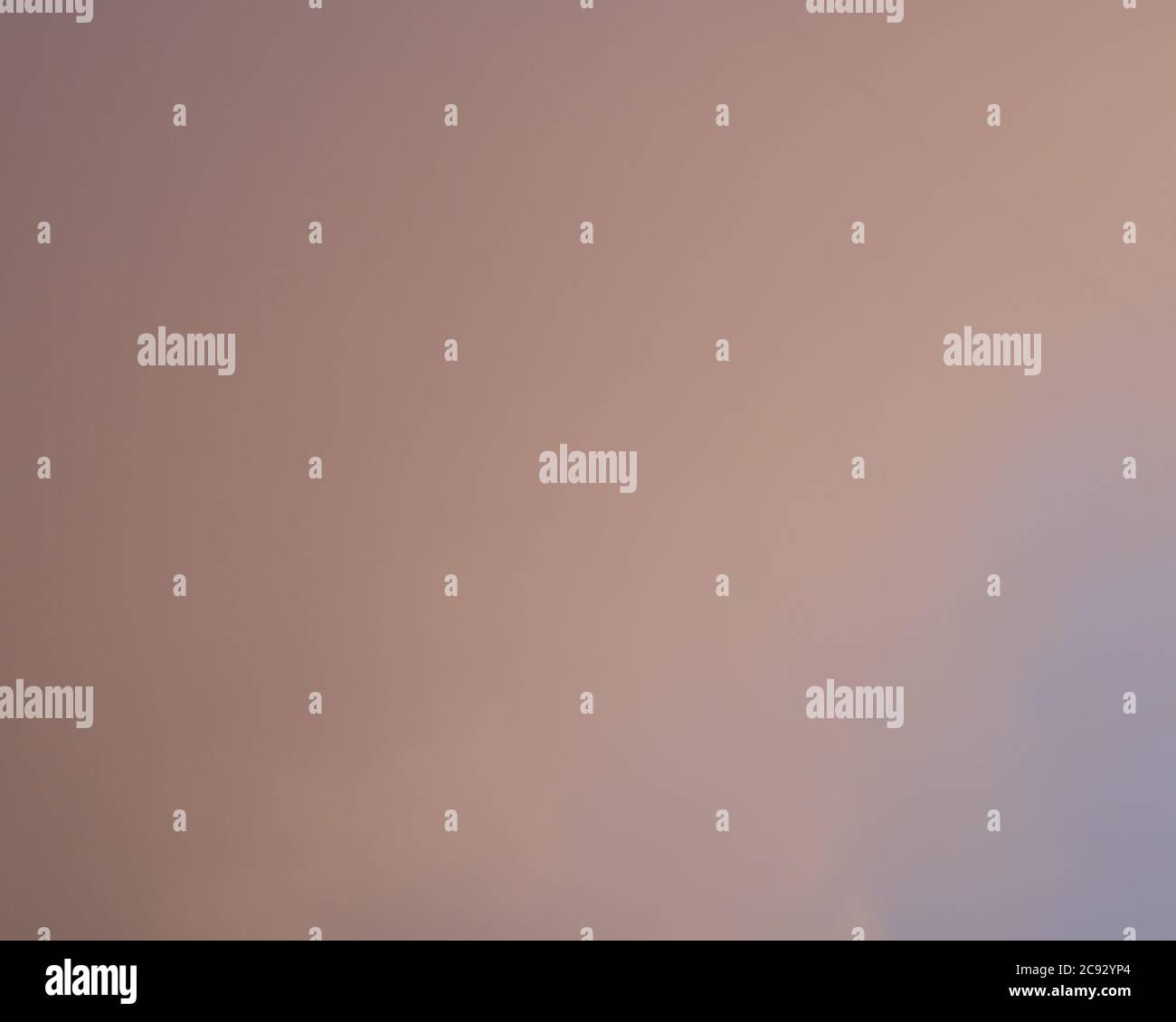 A coral hue cloud background with a small part of the blue sky in the ...