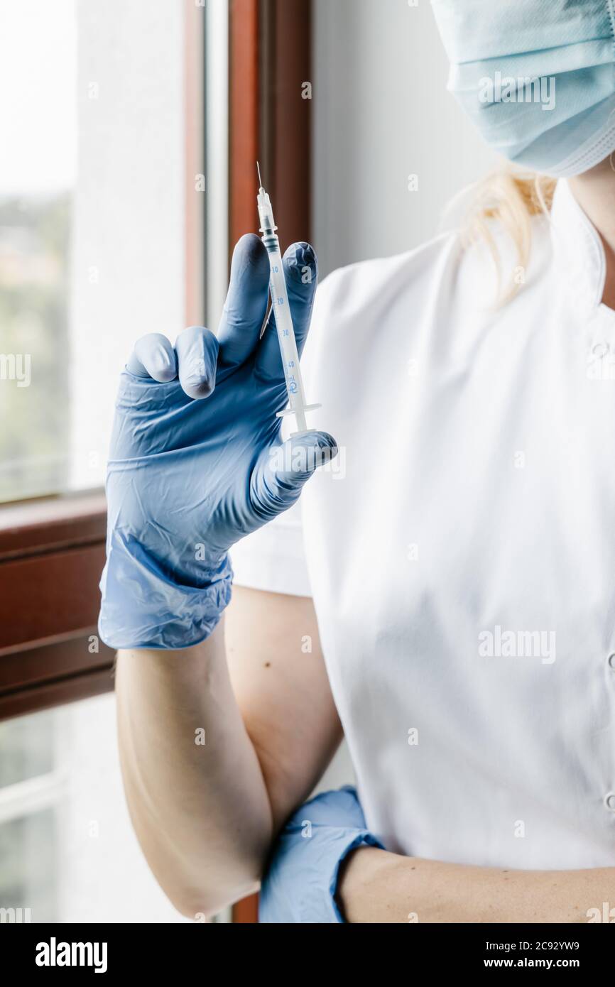 Needle in doctors hand Stock Photo - Alamy