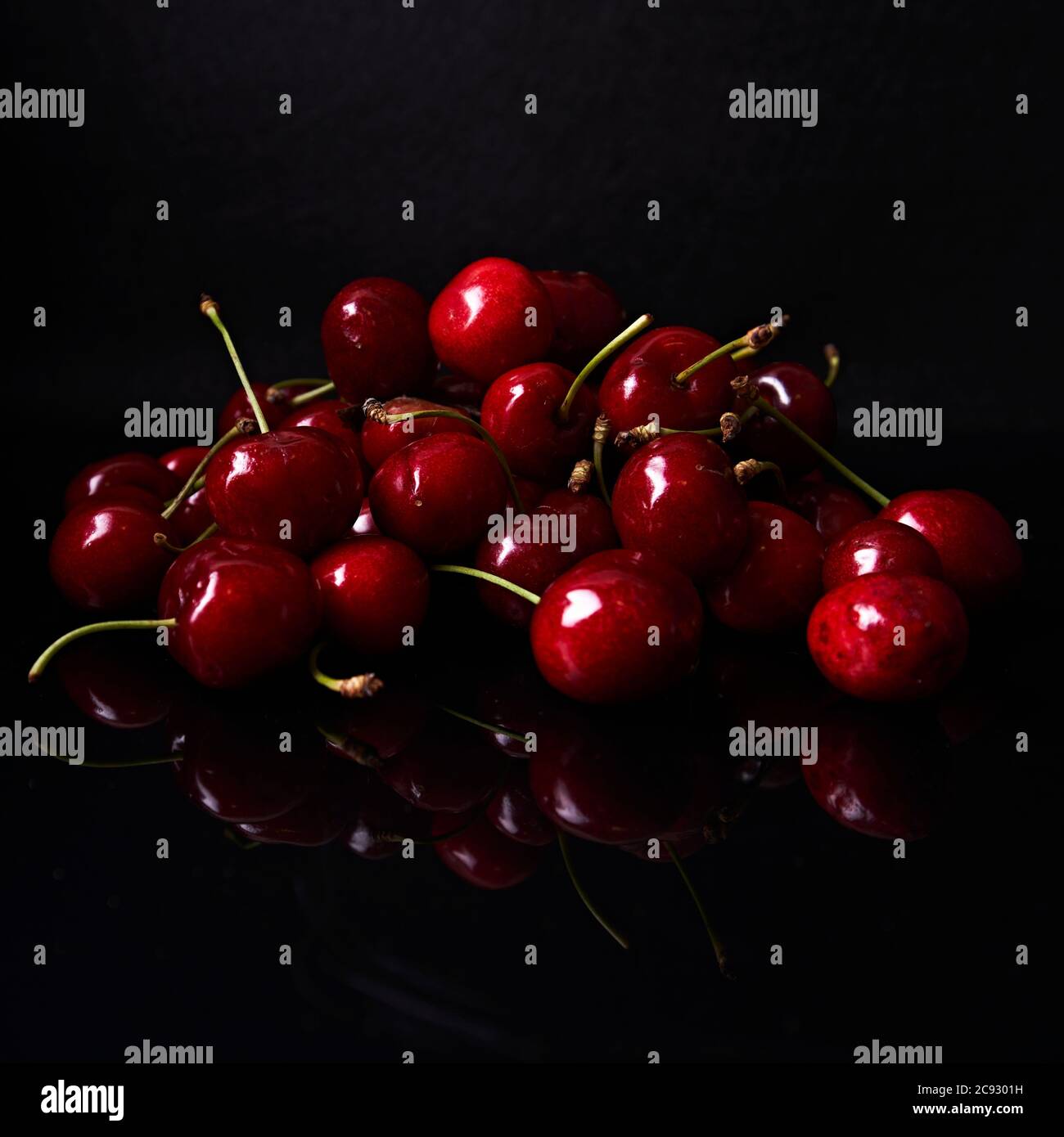 cherry still life on black background Stock Photo - Alamy