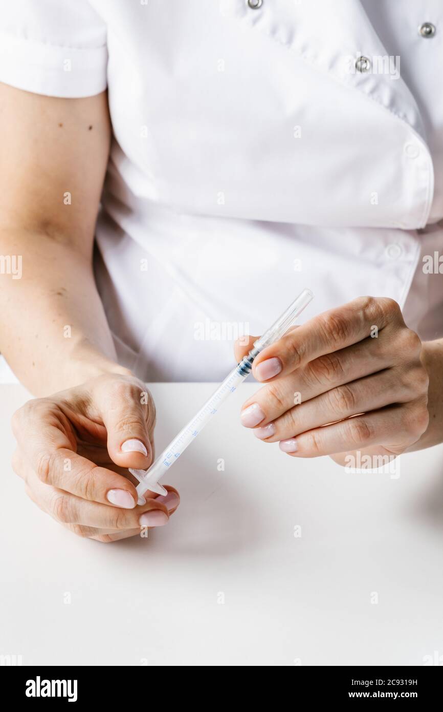 Needle in doctors hand Stock Photo - Alamy