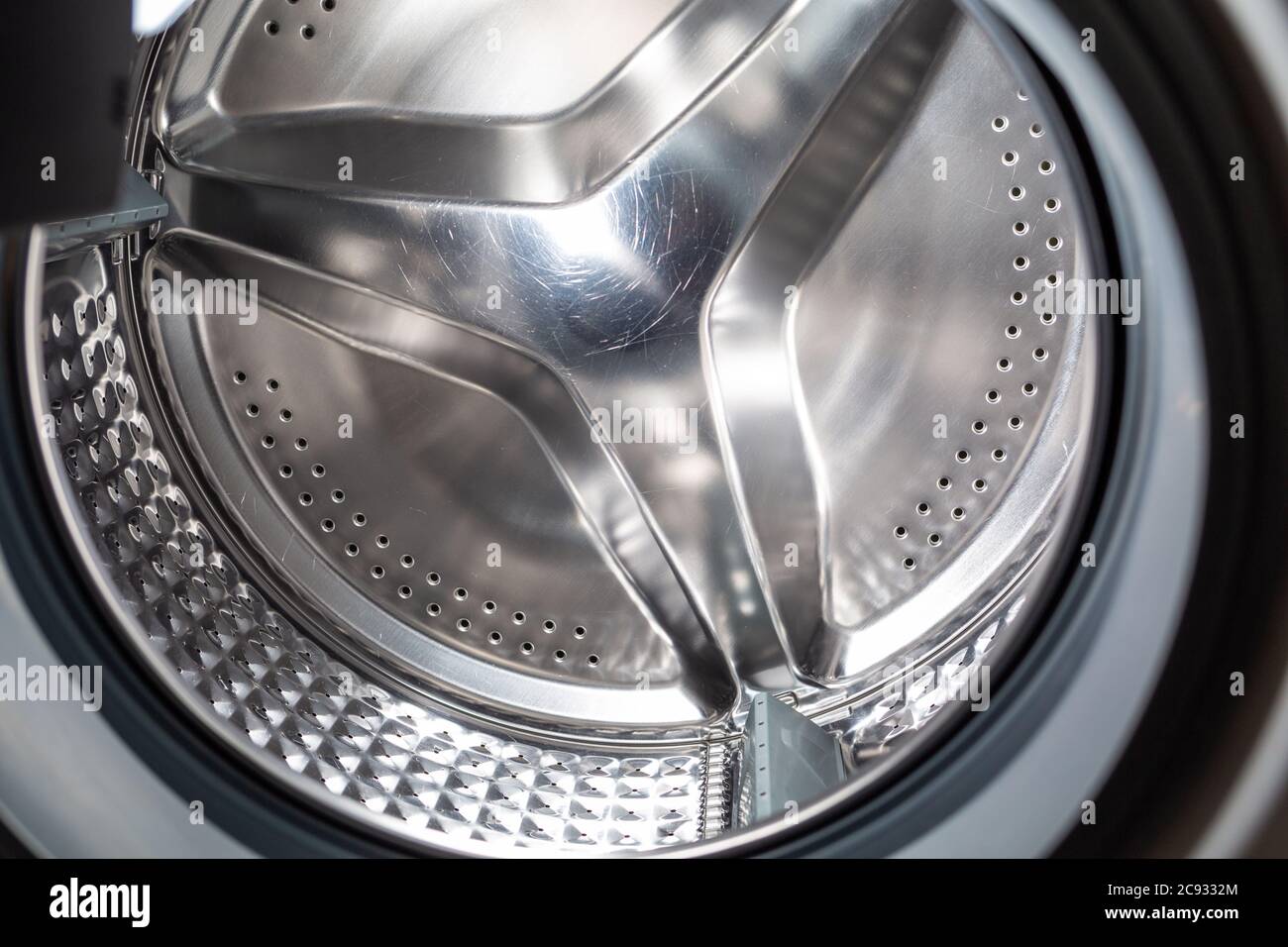 Clean shiny scratch on the drum of the washing machine closeup. The ...