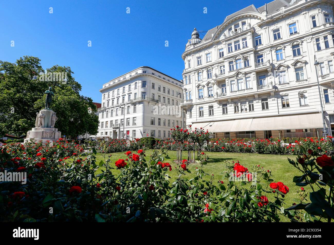Square with red roses and residential buildings on background in Vienna ...