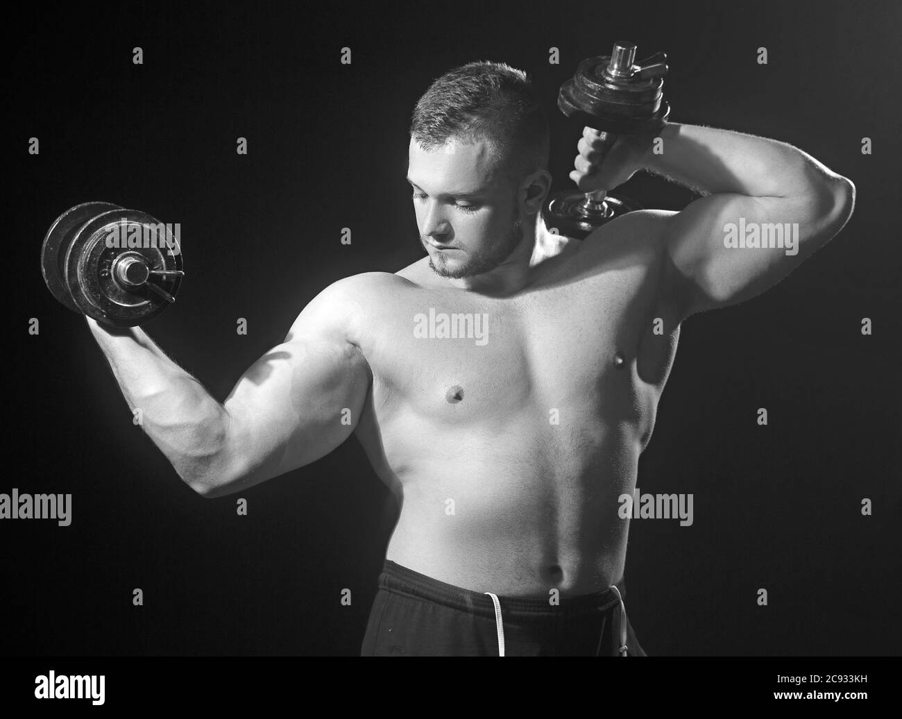 Fitness - big powerful muscular man lifting weights Stock Photo - Alamy