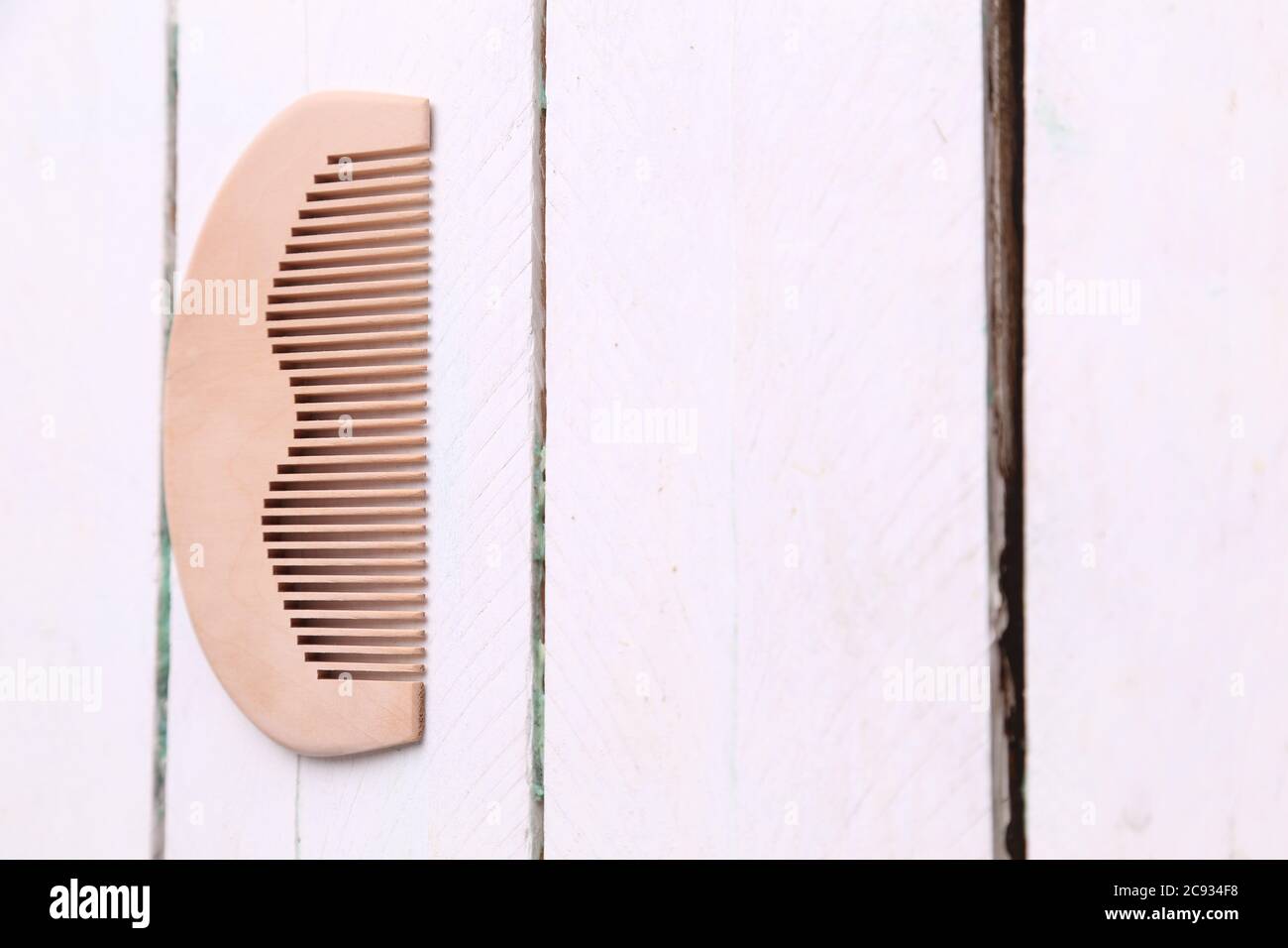 Top view of brown comb on a white wooden surface Stock Photo - Alamy