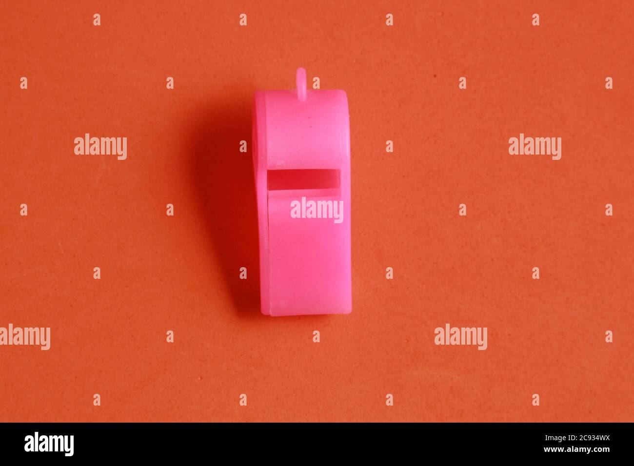 Pink whistle shaped plastic toy in color background Stock Photo - Alamy