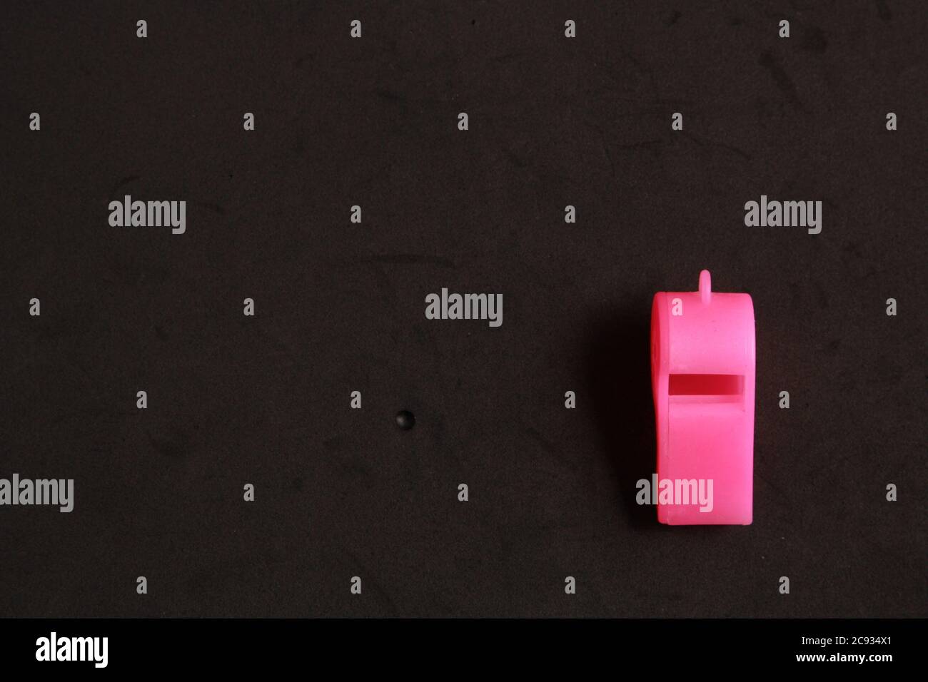 Pink whistle shaped plastic toy in black background Stock Photo - Alamy